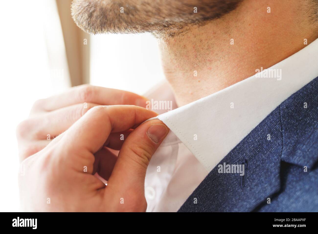 Bearded modern adult man buttoning up his shirt Stock Photo - Alamy