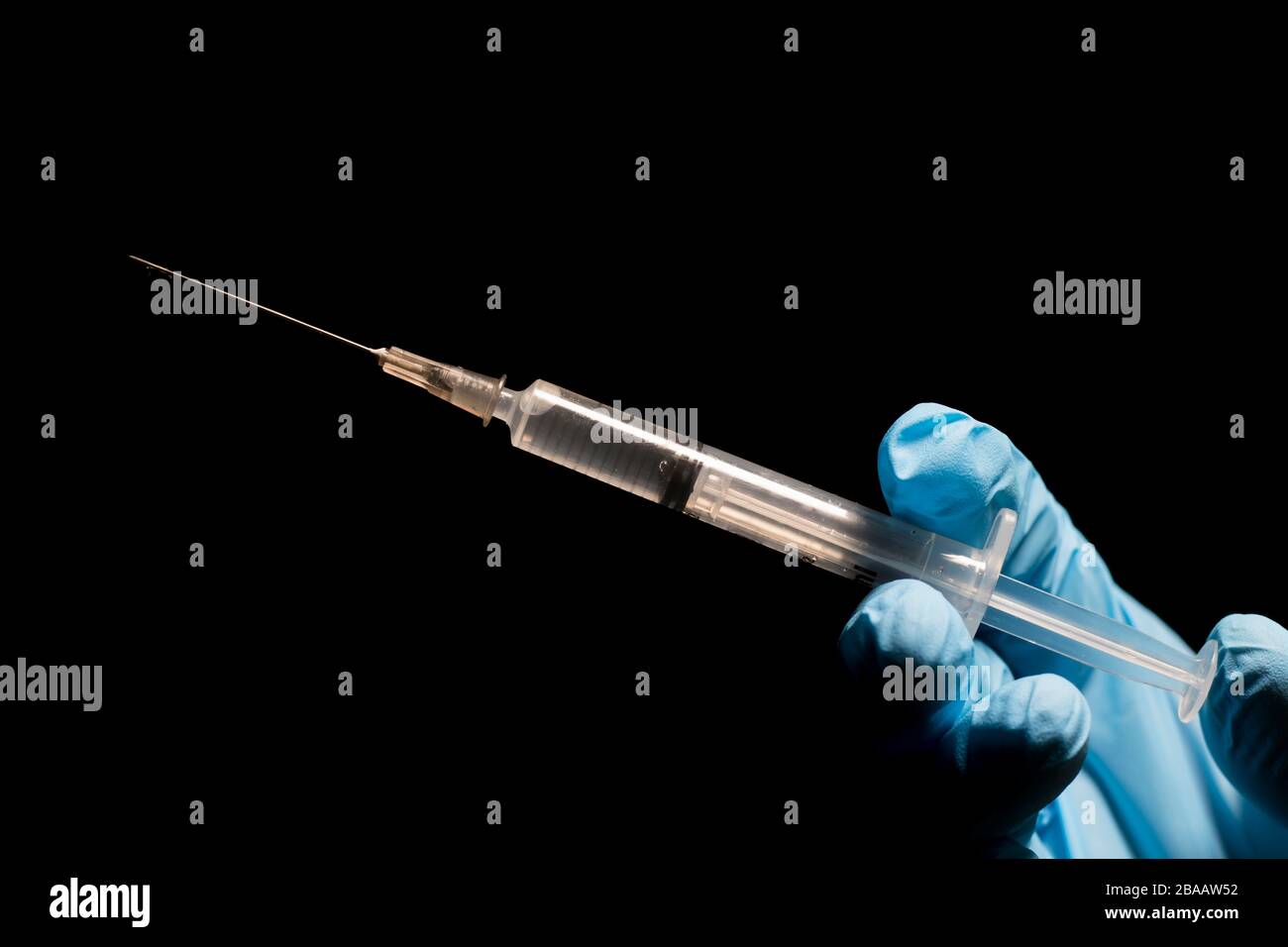 Vaccine needle with gloved doctors hand close up. Healthcare and ...