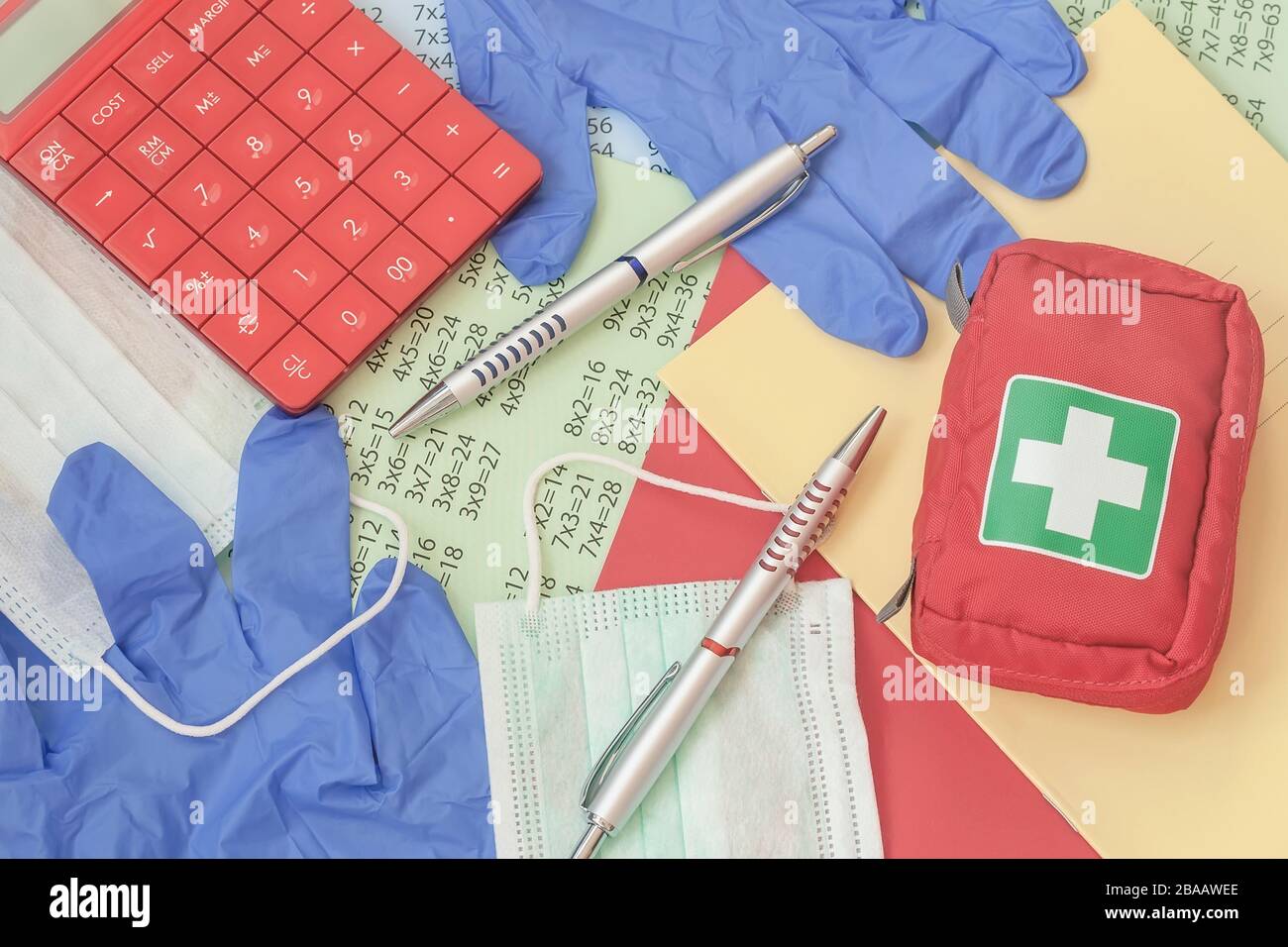 Pens, Calculator, medical masks and first aid kit on a school notebook ...