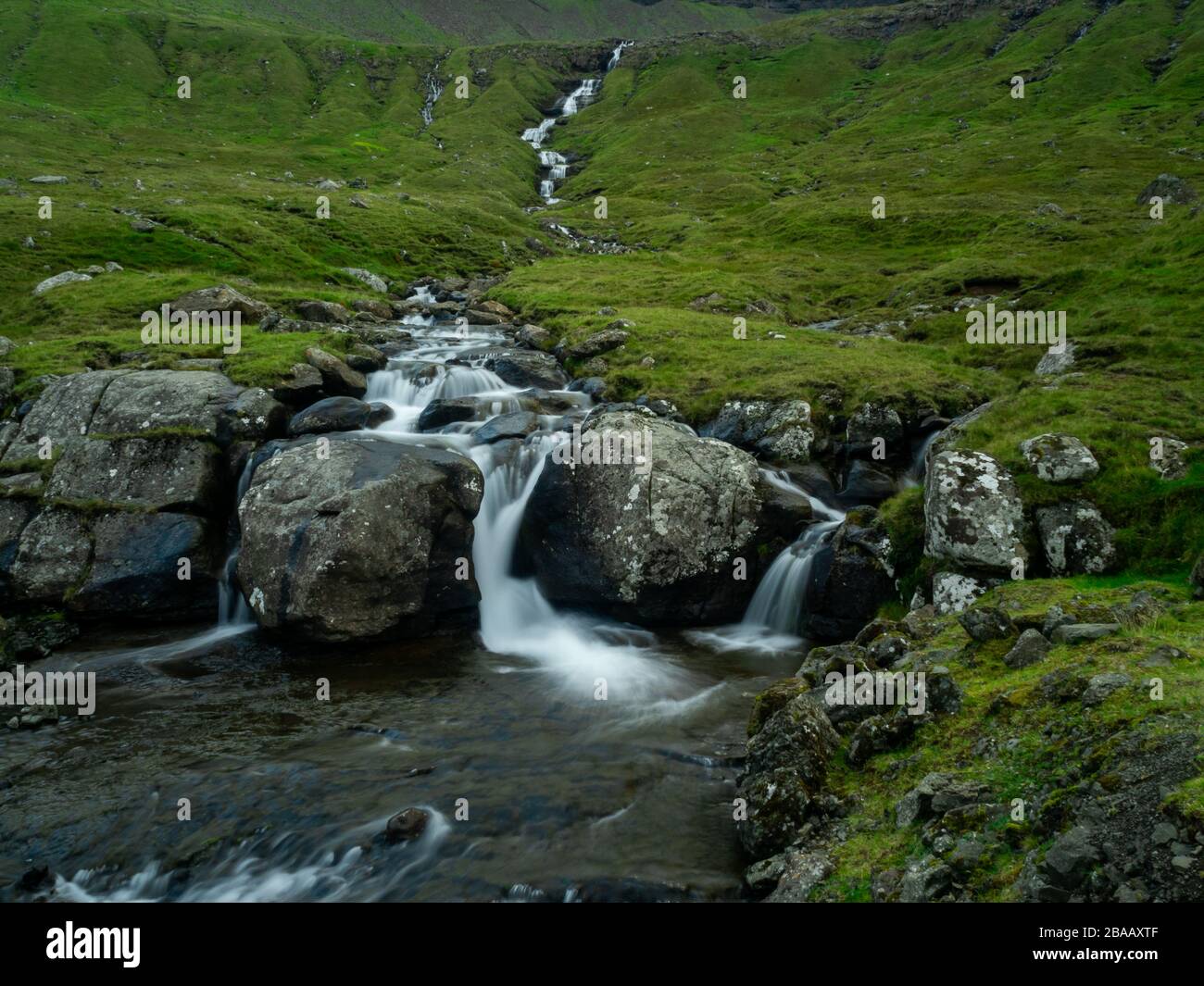 Faroe Islands, one of many waterfalls on road to abandoned town Muli ...