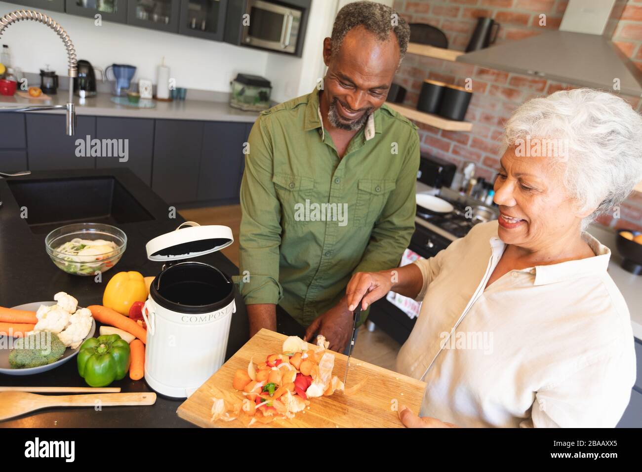 Senior African American couple using compost bin in kitchen Stock Photo ...
