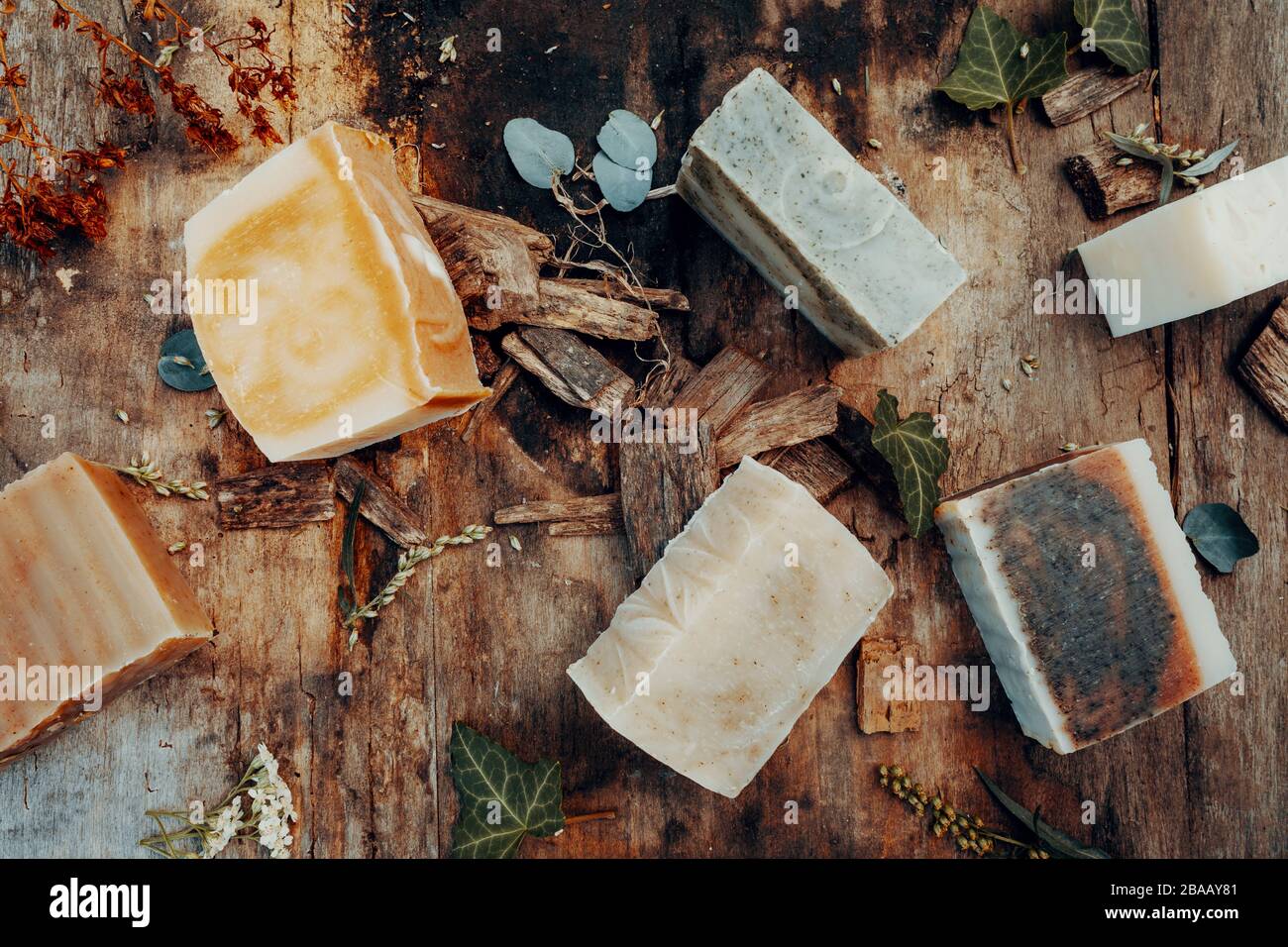 Various handmade natural soaps on a vintage wooden table with ...