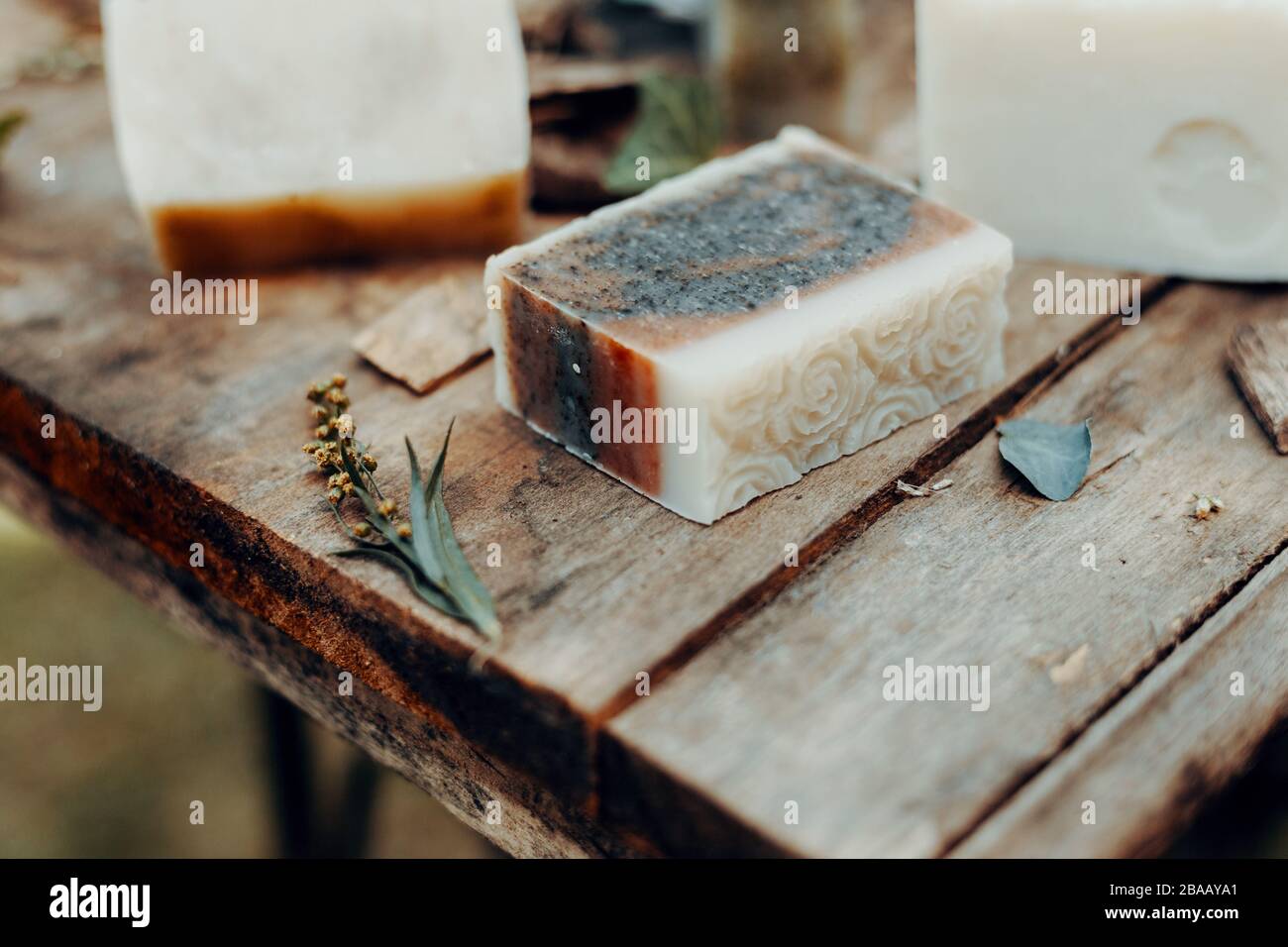 Various handmade natural soaps on a vintage wooden table with ...