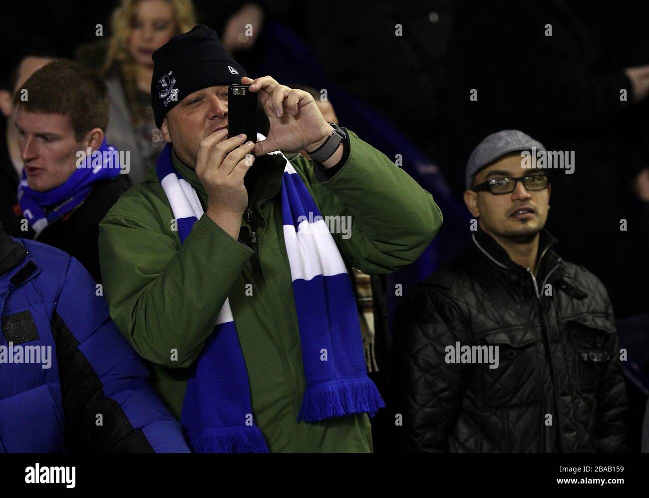 An Everton fan in the stands takes a picture on his phone Stock Photo ...