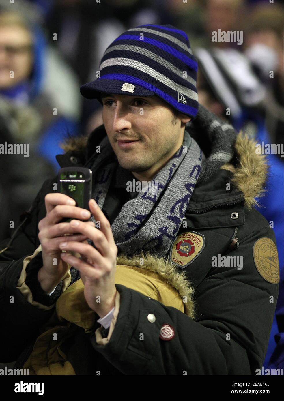 An Everton fan in the stands takes a picture on his phone Stock Photo ...