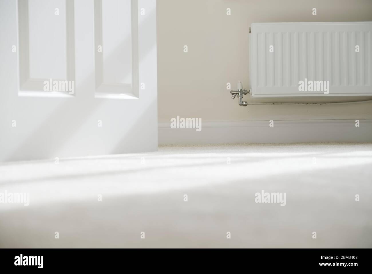 New white radiator white on pale wall house interior Stock Photo - Alamy
