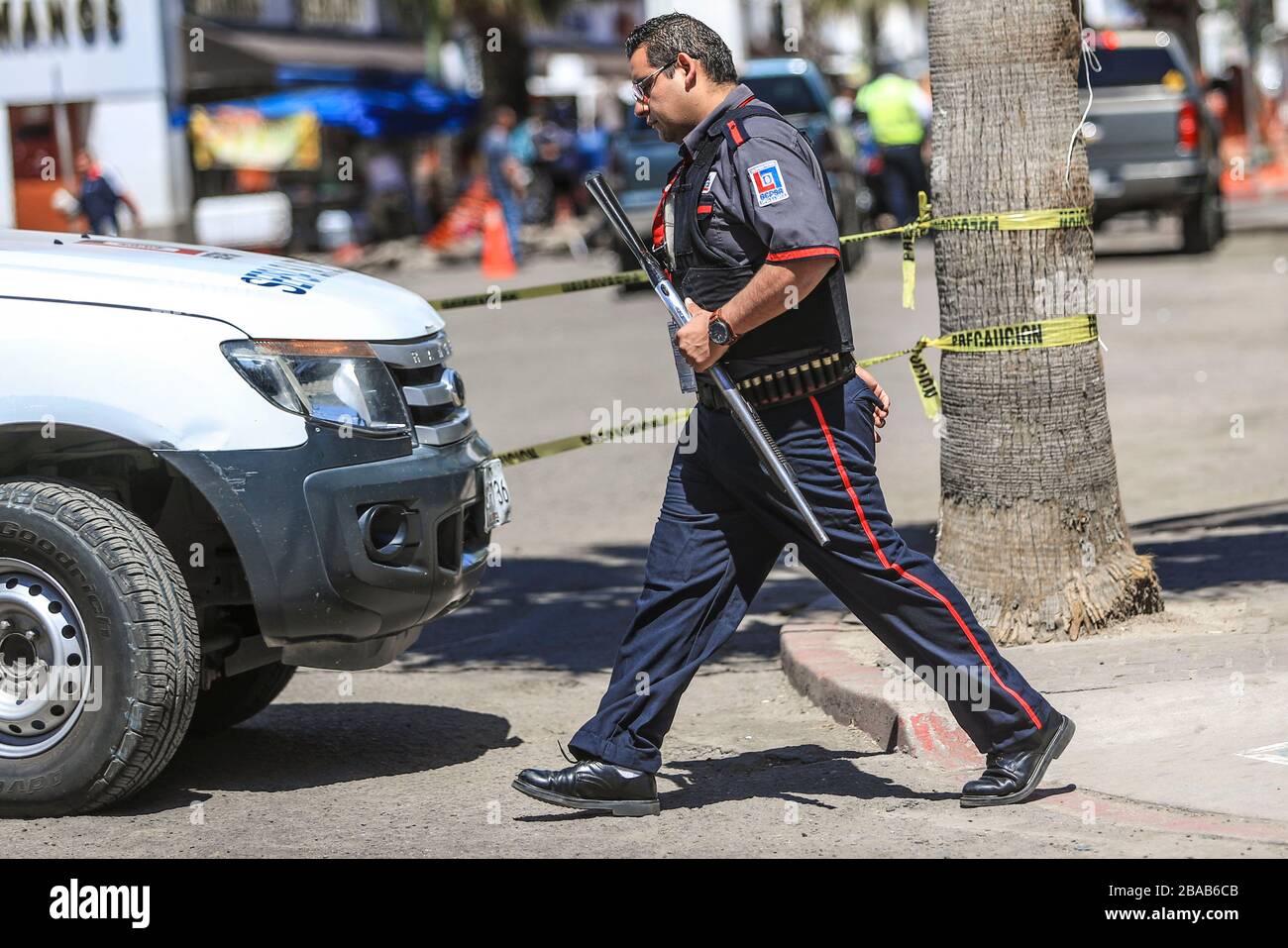 A guard from the Private Security company, SEPSA walks with his firearm ...
