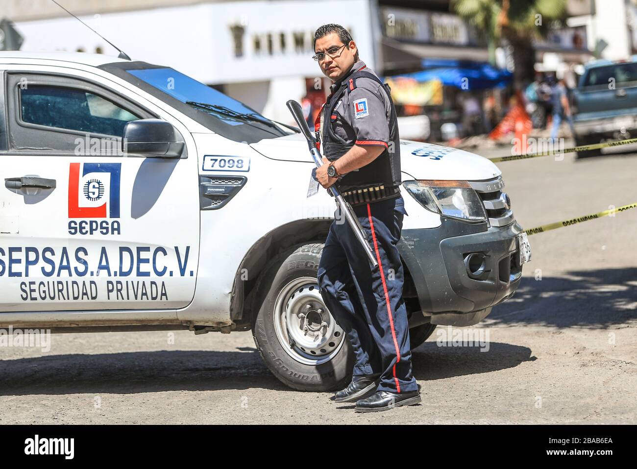 A guard from the Private Security company, SEPSA walks with his firearm ...