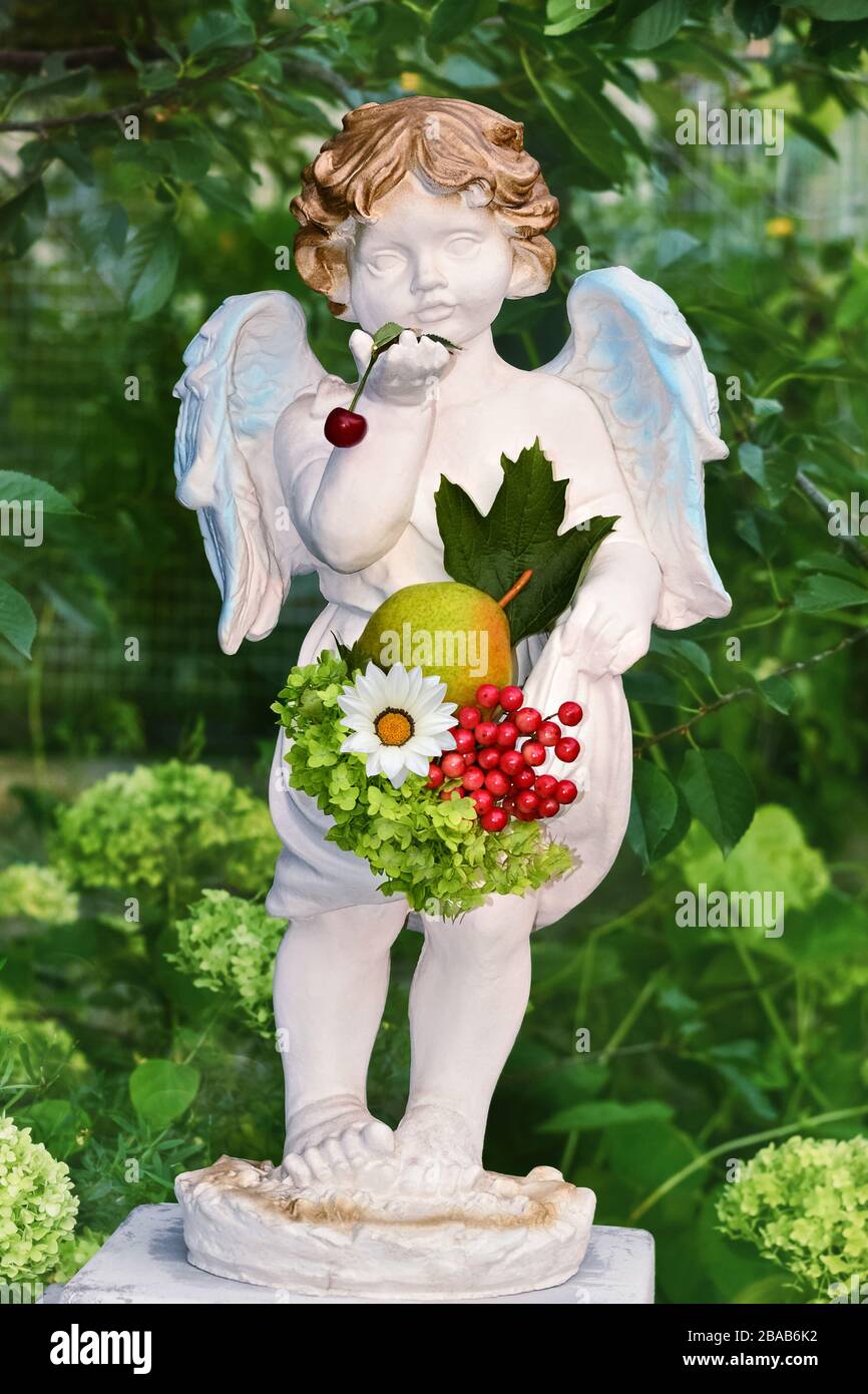 Sculpture of an angel in the garden holding flowers and fruit Stock ...