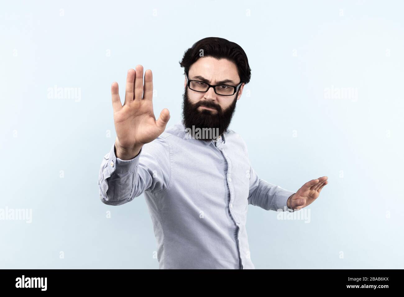 bearded man standing and raising his palm doing the stop sign with a ...