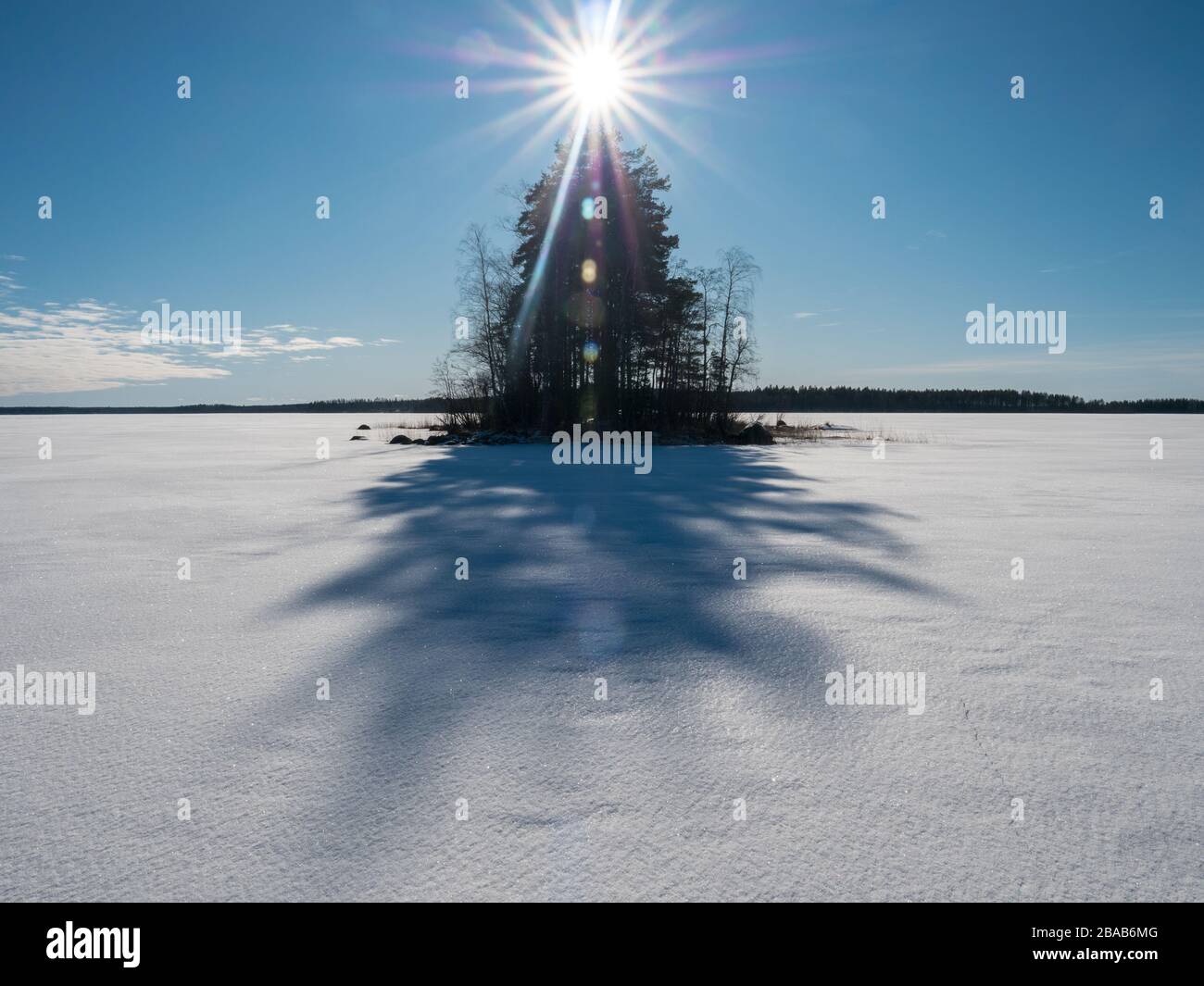 Small island and bright sun at frozen lake Stock Photo - Alamy