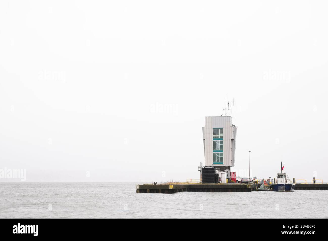 Maritime navigation building tower at coastal dock pier Stock Photo - Alamy
