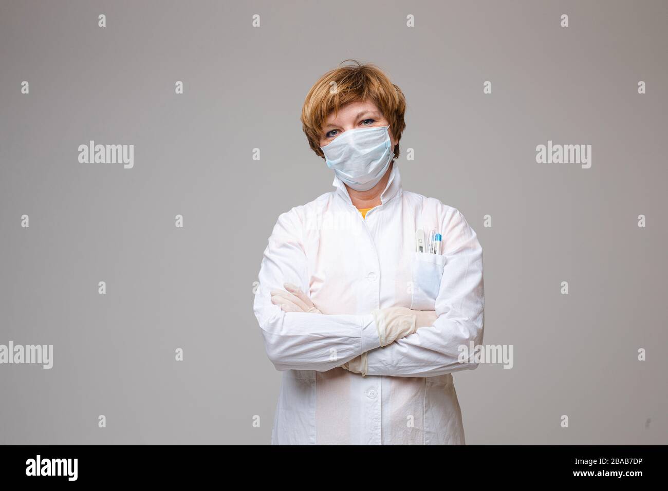 Serious paramedic in robe and mask looking at camera Stock Photo - Alamy
