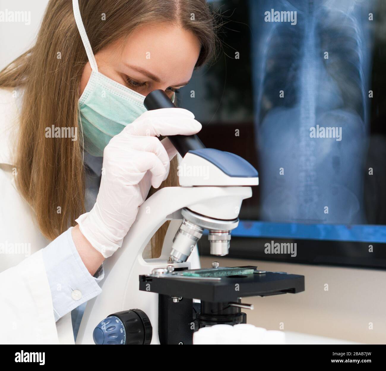 Scientist in medical mask in laboratory. Pneumonia x-ray film on ...