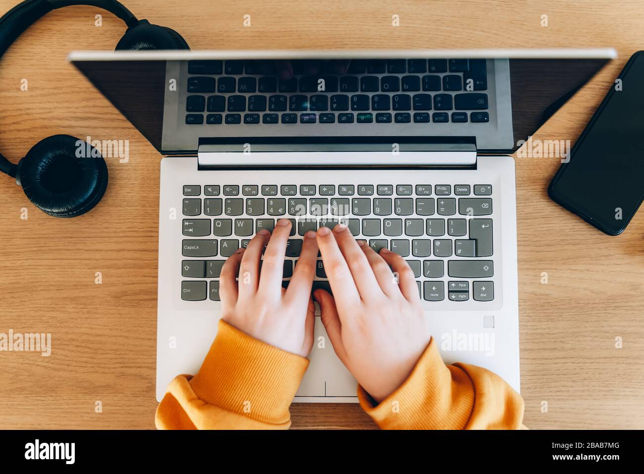 School age girl is home schooling using laptop during self isolation at ...