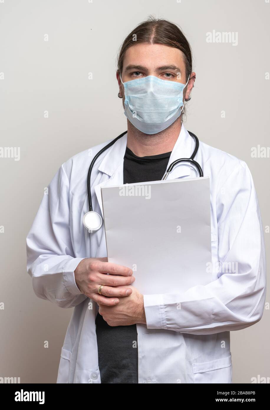 Young doctor wearing protection mask against epidemy and stethoscope is ...