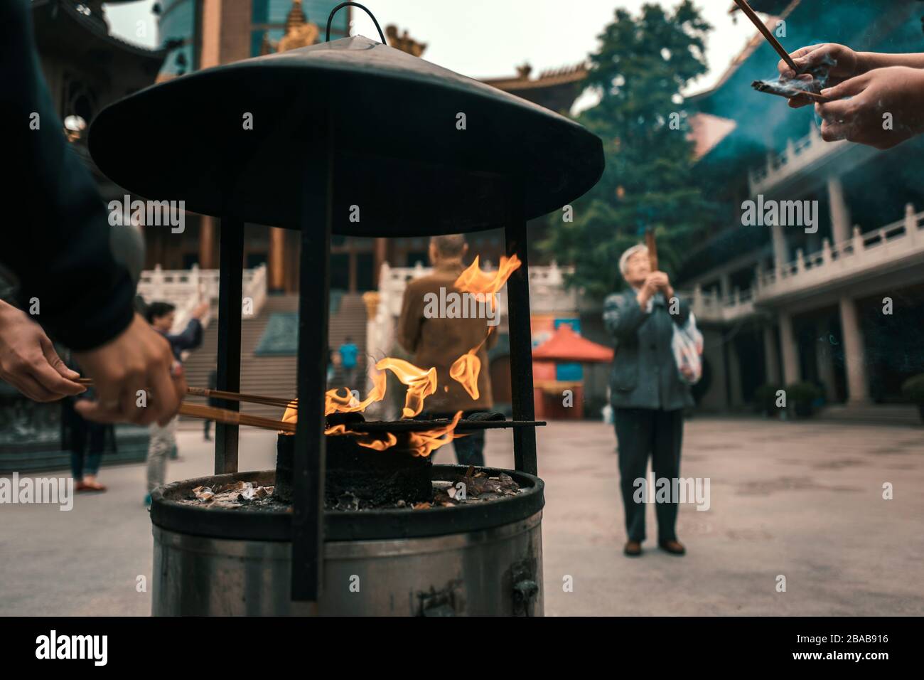 People burning incense in a temple Stock Photo - Alamy
