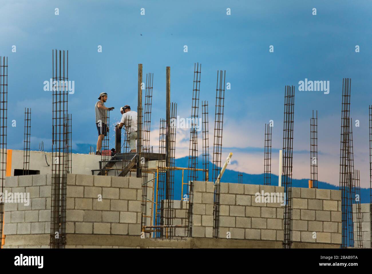 Two construction workers work or rooftop, welding metal railing Stock ...