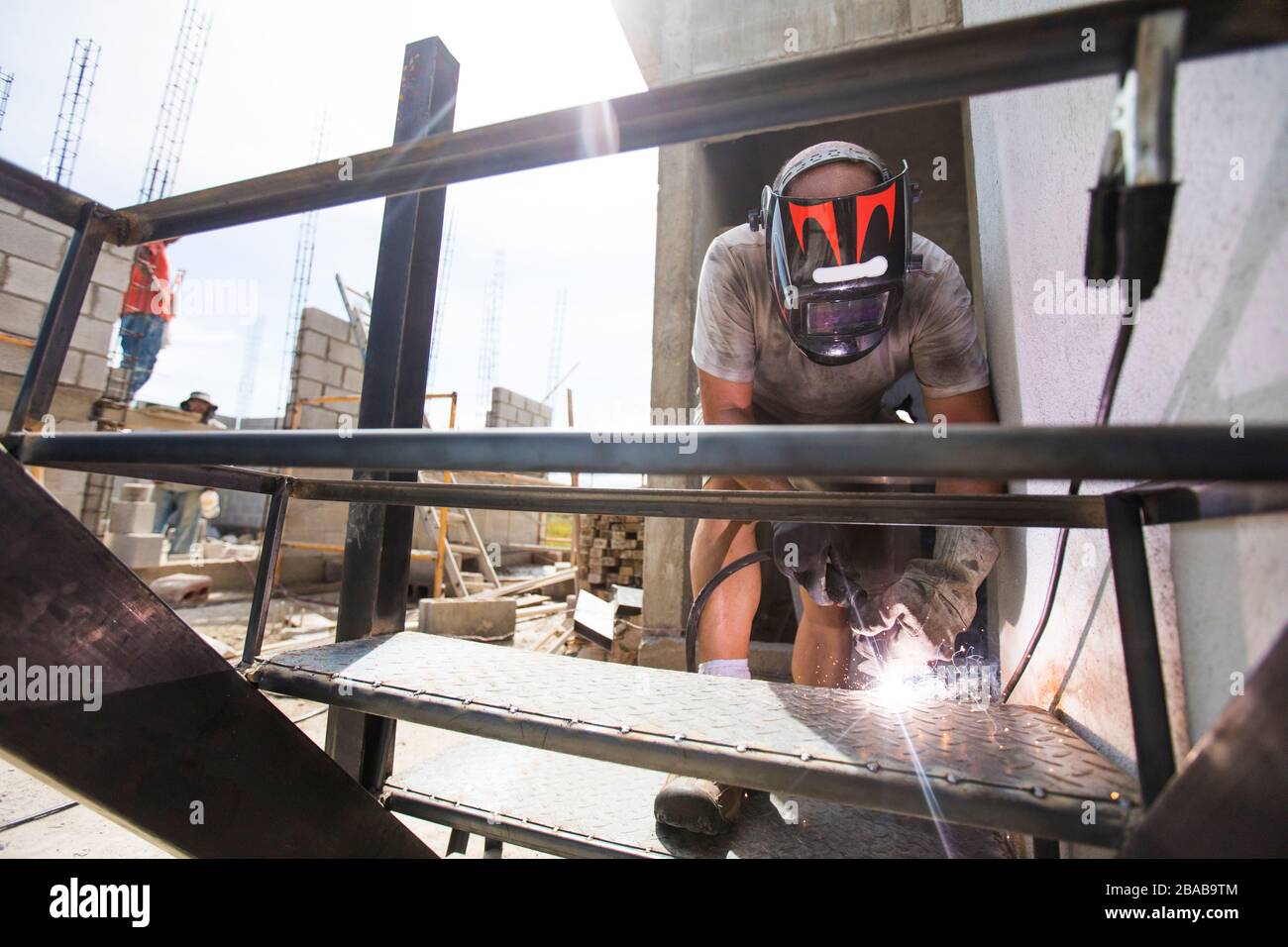 construction site worker welding staircase at building site Stock Photo ...