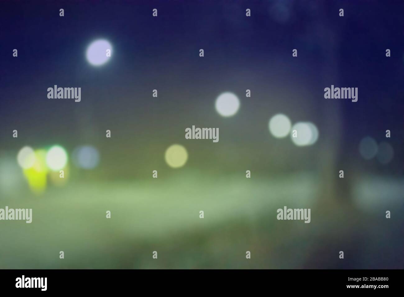 city lights and shiny snow. Night winter blurred background. Winter ...