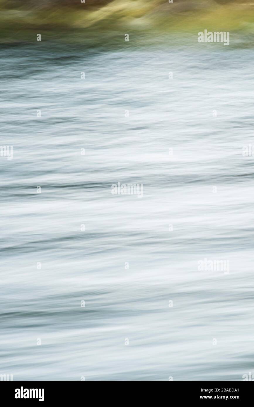Texture of fast moving water, in bluish, greyish, green soft tones ...