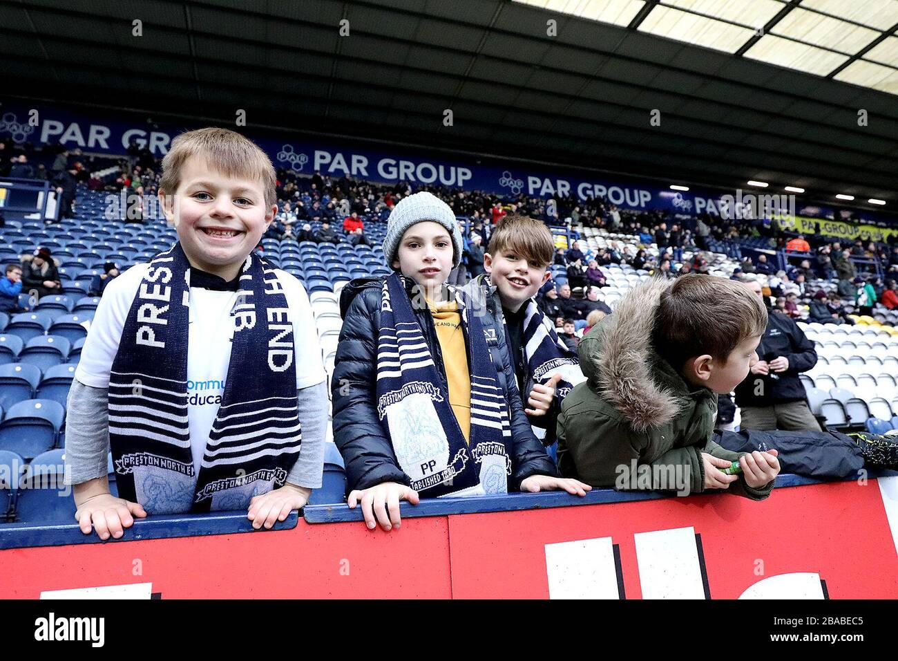A group of young Preston fans watch the players warm up before the game ...
