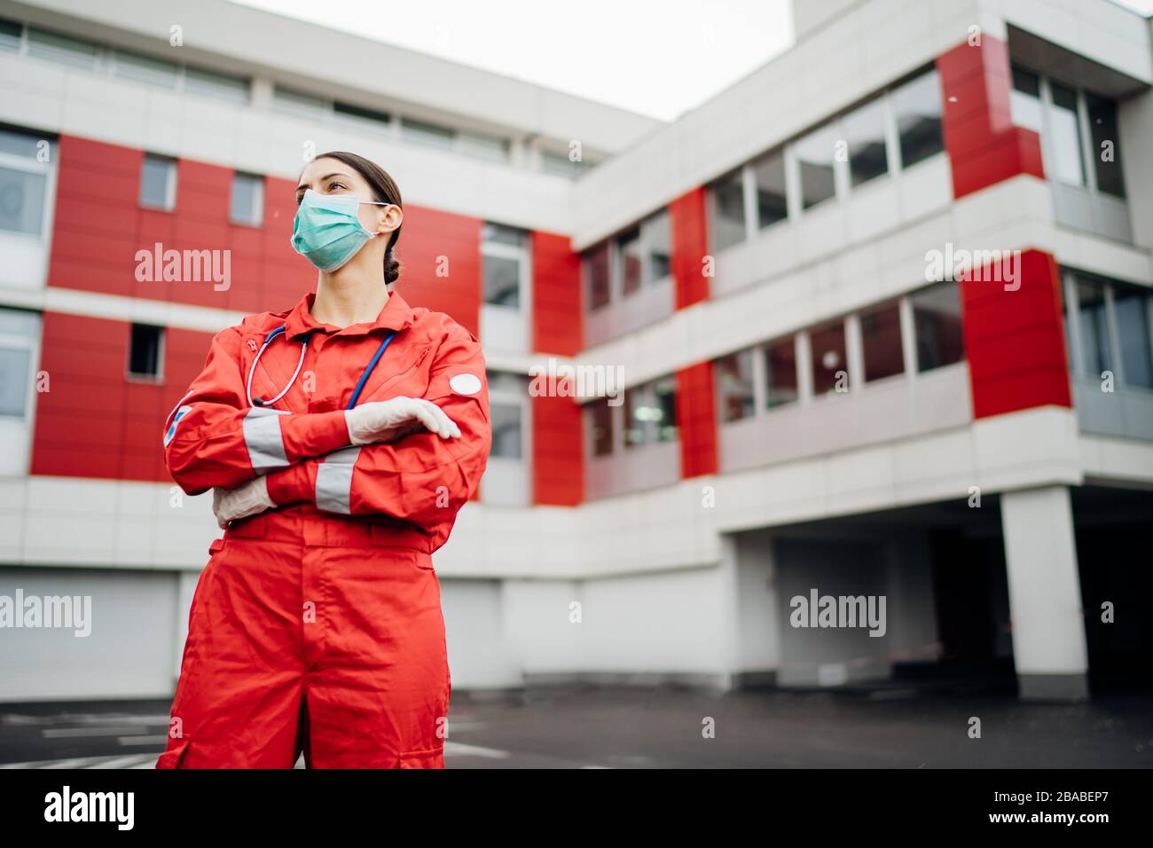 Sad overworked paramedic in uniform in front of isolation hospital ...