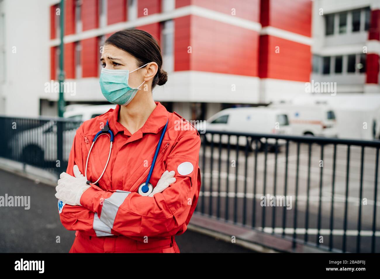 Crying paramedic in front of isolation hospital facility.Mental melt ...