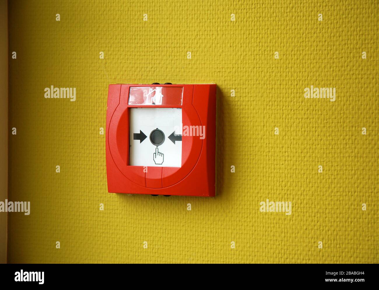 Fire alarm button on a yellow wall Stock Photo - Alamy