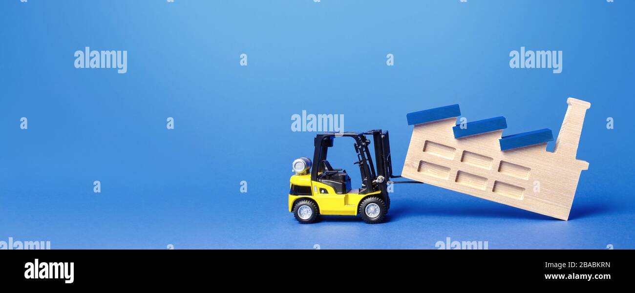 Forklift truck transports a factory plant to new location. Revision of ...