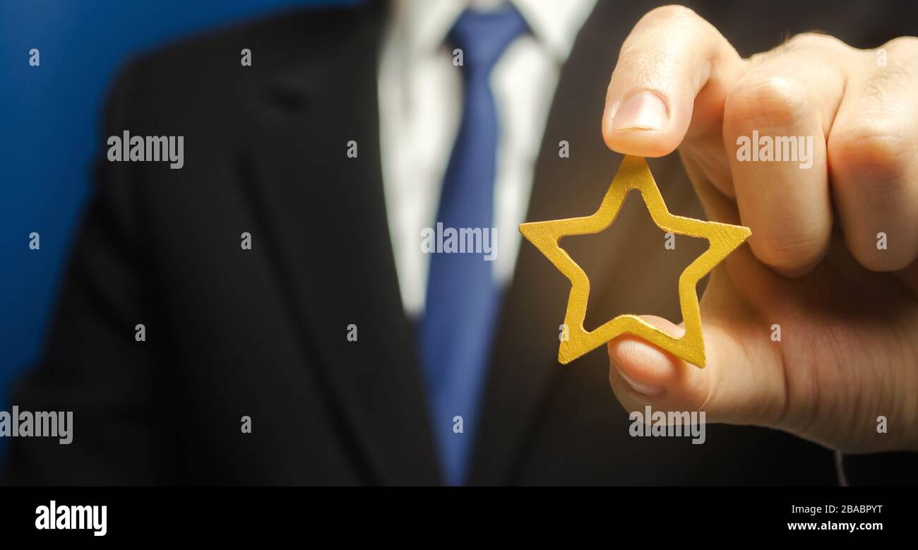 Man holds a golden star in his hand. Symbol of success and excellence ...