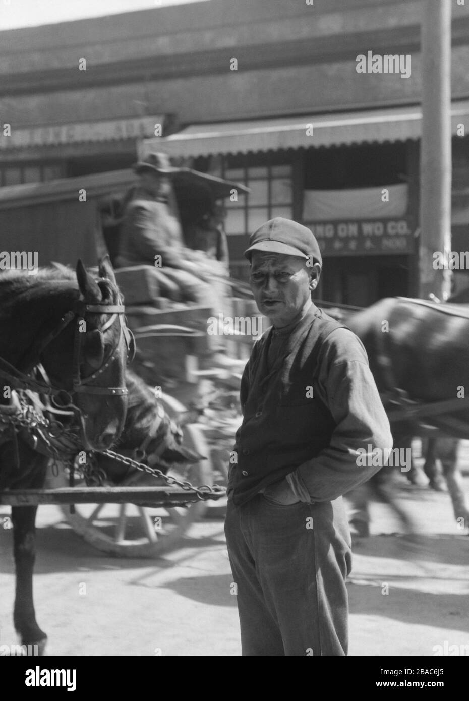 Portrait of middle aged Chinese-American man standing near wagon ...