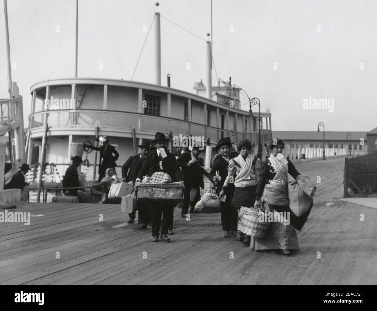 Italian immigrants landing at Ellis Island, c. 1892-1910. They have ...