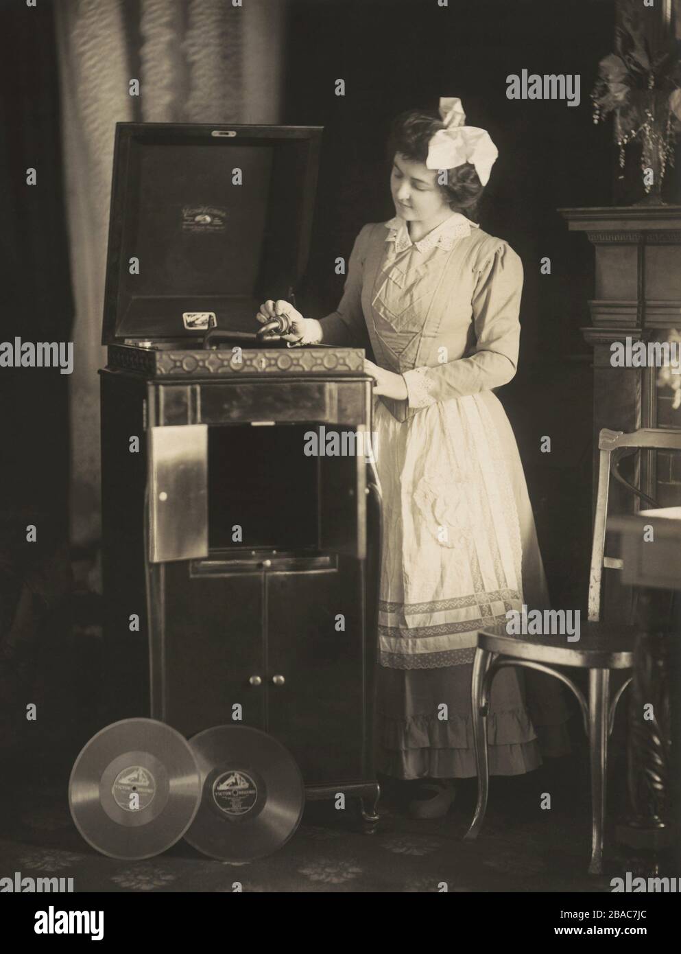 Woman beginning to play a phonograph in 1908. the Product photo shows ...