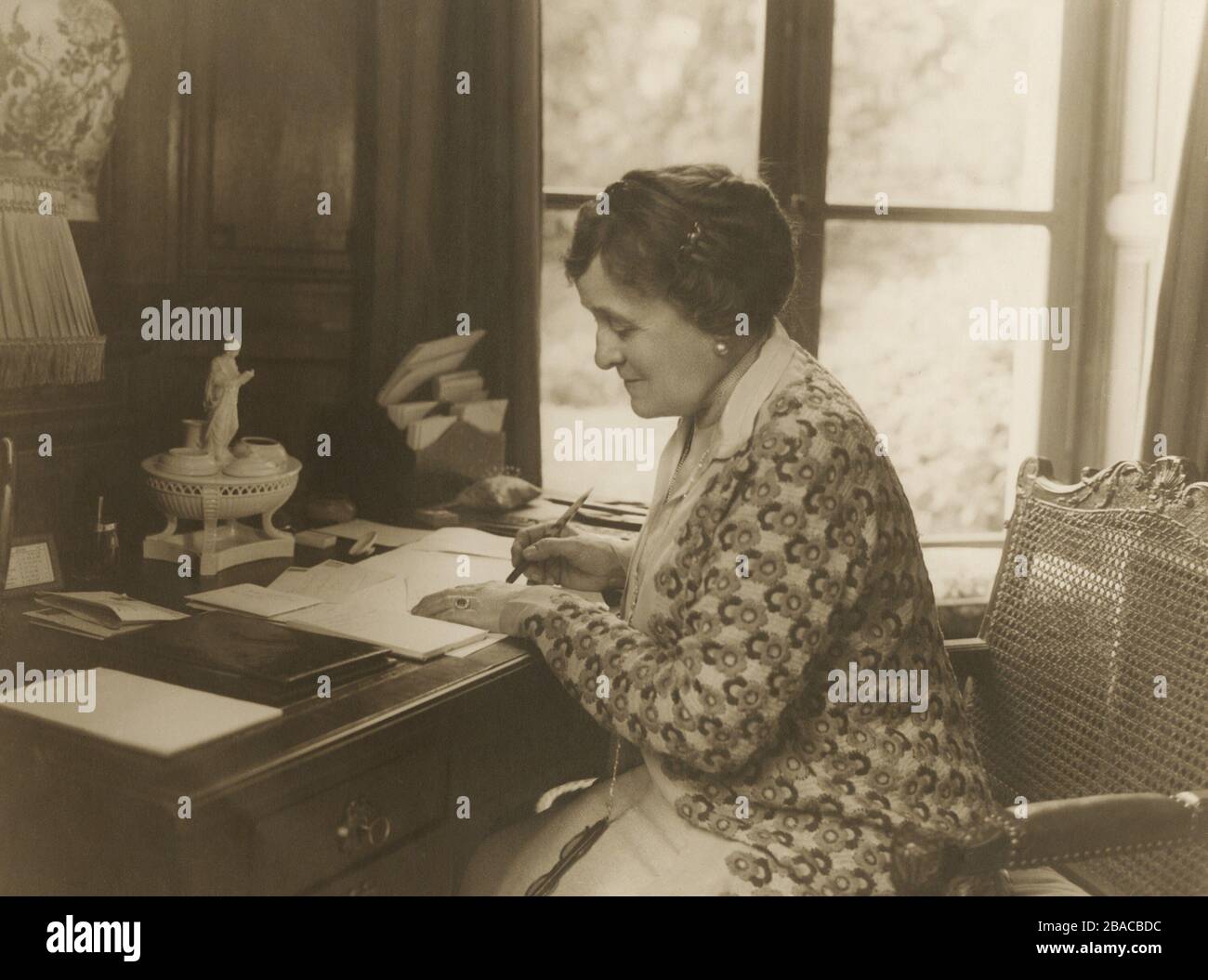 Edith Wharton, writes at her desk in 1920. She is best known for her ...