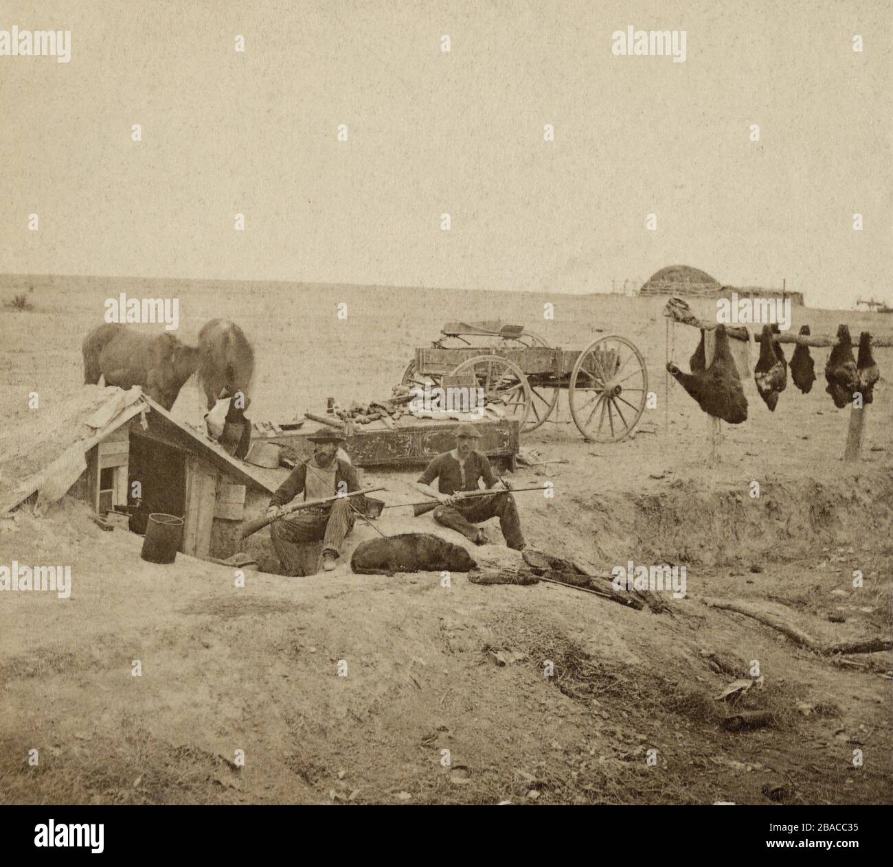 Buffalo hunter's dugout home and encampment, ca. 1870. The two hunters ...