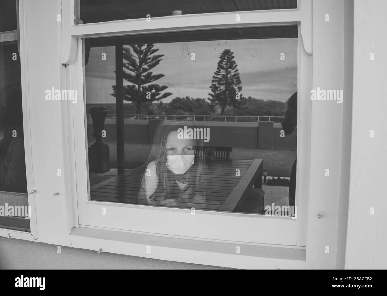 COVID-19 Lockdown. Depressed lonely little girl with face mask looking ...