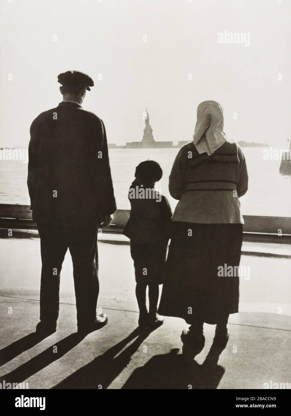 Immigrant family views the Statue of Liberty from the Ellis Island, US ...