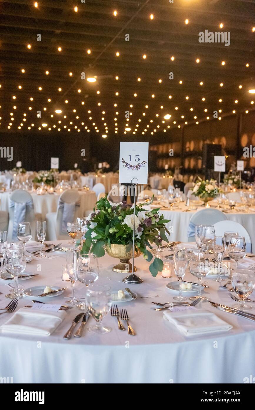 Vertical shot of numbered wedding table settings with beautiful floral ...