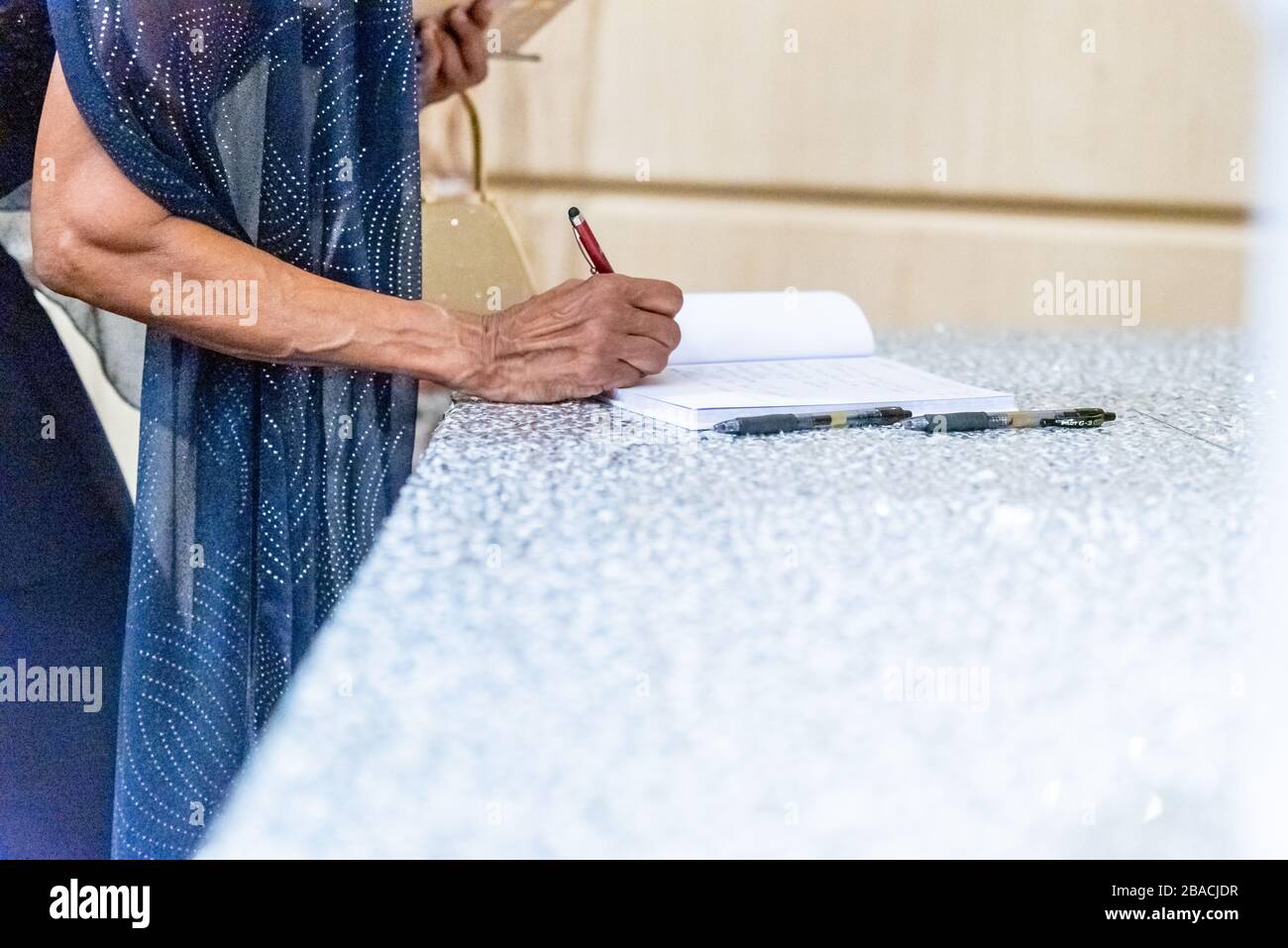 Person signing marriage registration documents at a wedding reception ...
