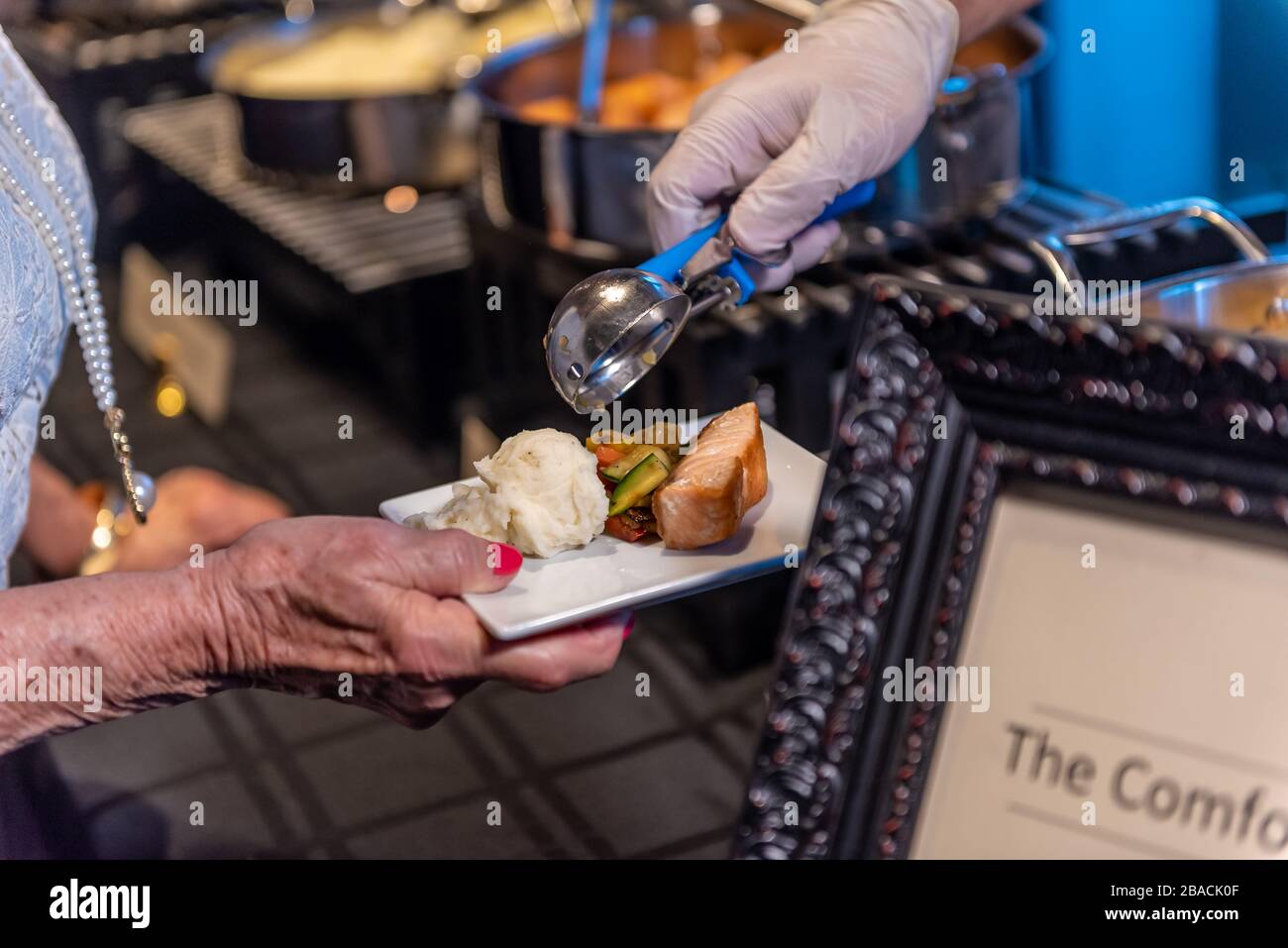 Waiter serving food to an old female at a wedding reception Stock Photo ...