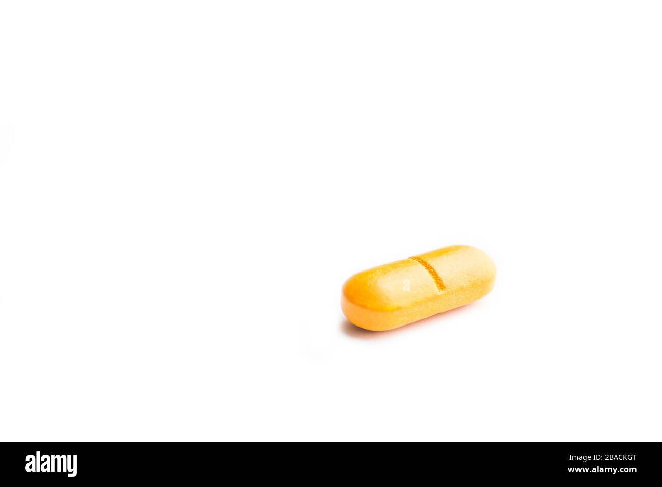 Closeup shot of a yellow pill on a white surface Stock Photo - Alamy