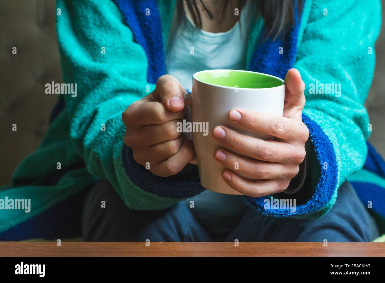 Woman in turquoise robes holding a cup of tea Stock Photo - Alamy