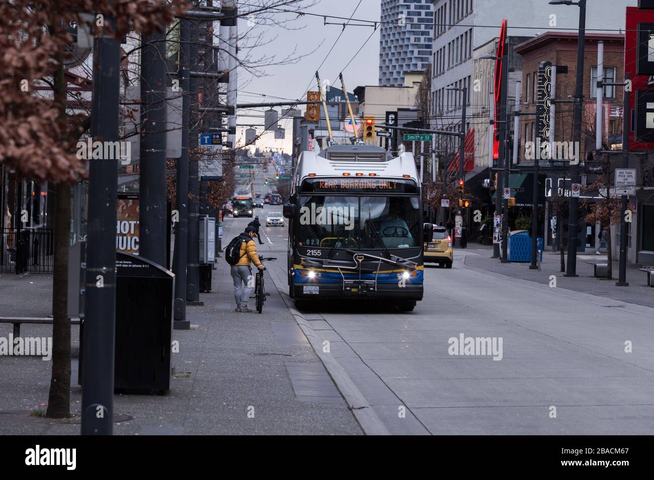 DOWNTOWN VANCOUVER, BC, CANADA - MAR 23, 2020: A cyclist takes his bike ...