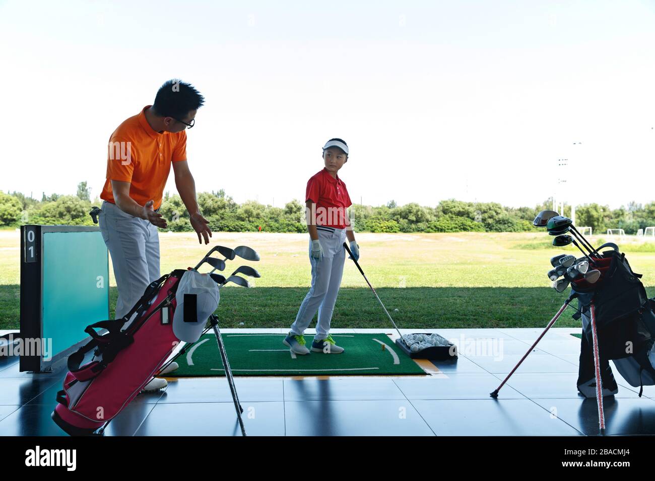 Golf practice field coaching children Stock Photo - Alamy
