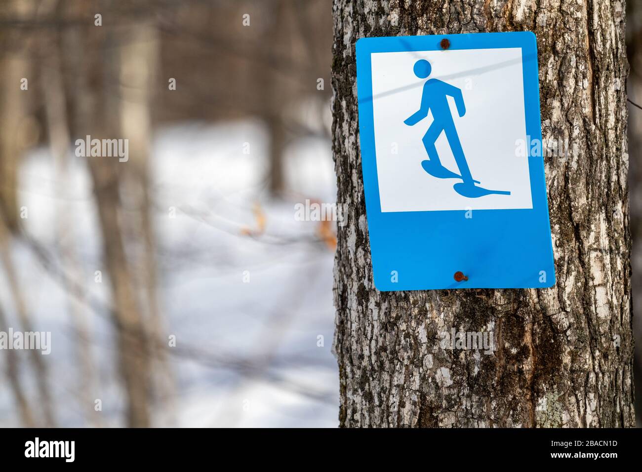 A blue-and-white sign features an illustration of a stick figure ...