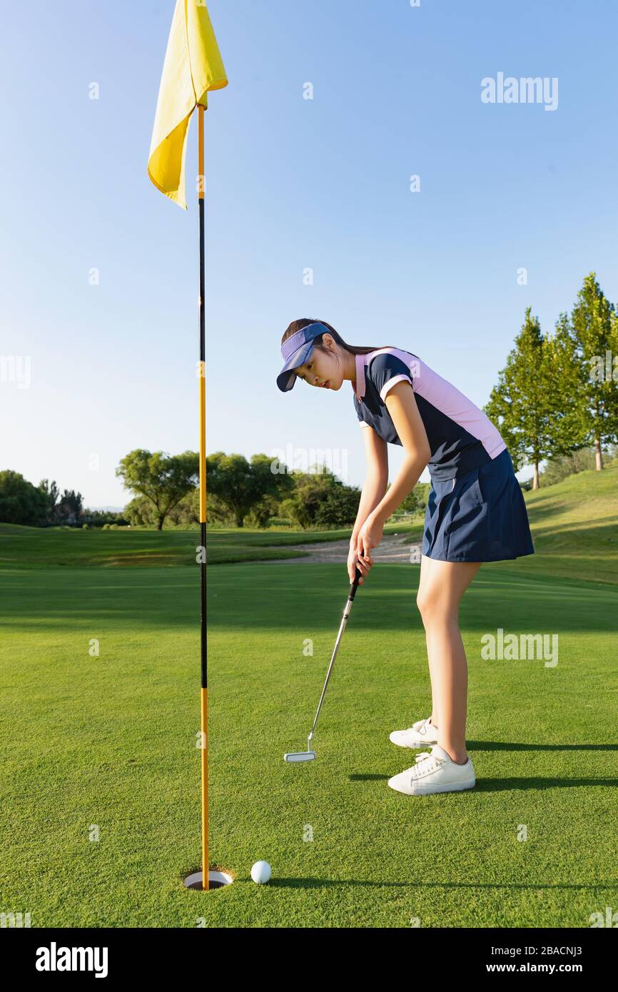 The young woman playing golf Stock Photo - Alamy