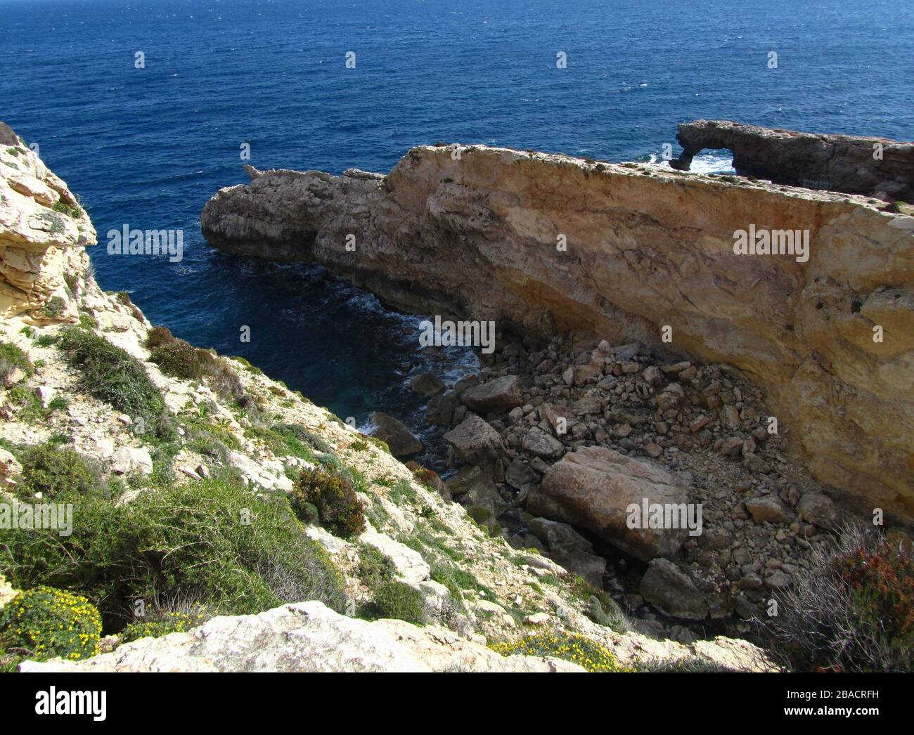 High angle shot of Ras il-Hamrija rock arch on Lapsi coastline, Maltese ...