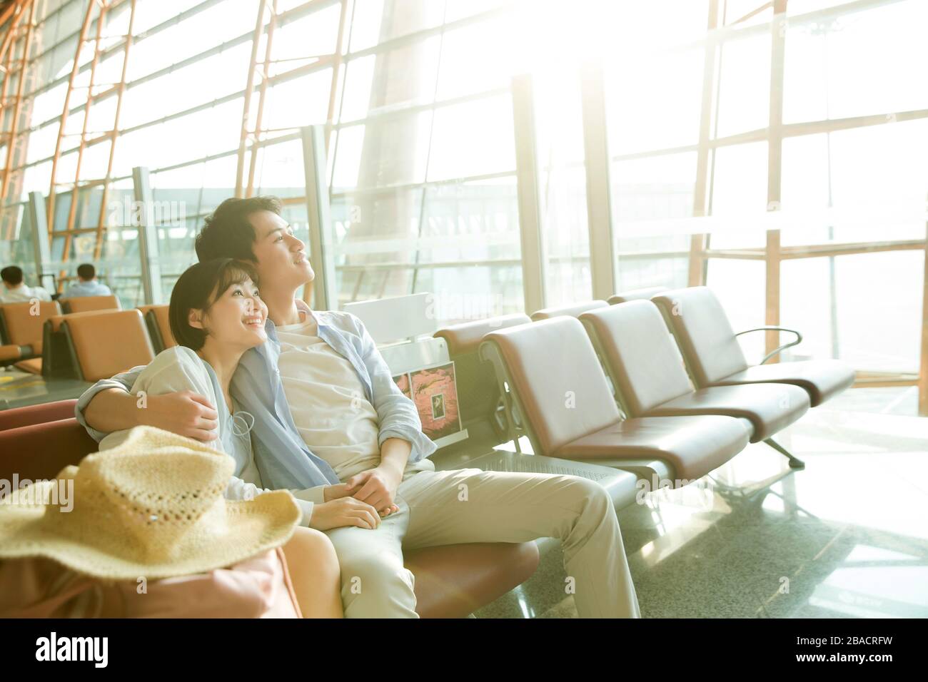 The young couple sitting in the airport lounge Stock Photo - Alamy