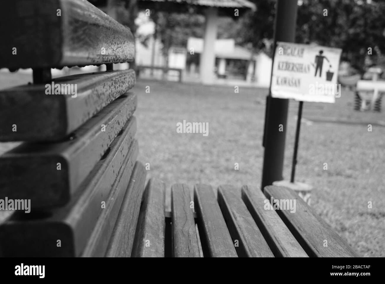 Park bench with a keep clean sign in Bahasa Melayu Stock Photo - Alamy